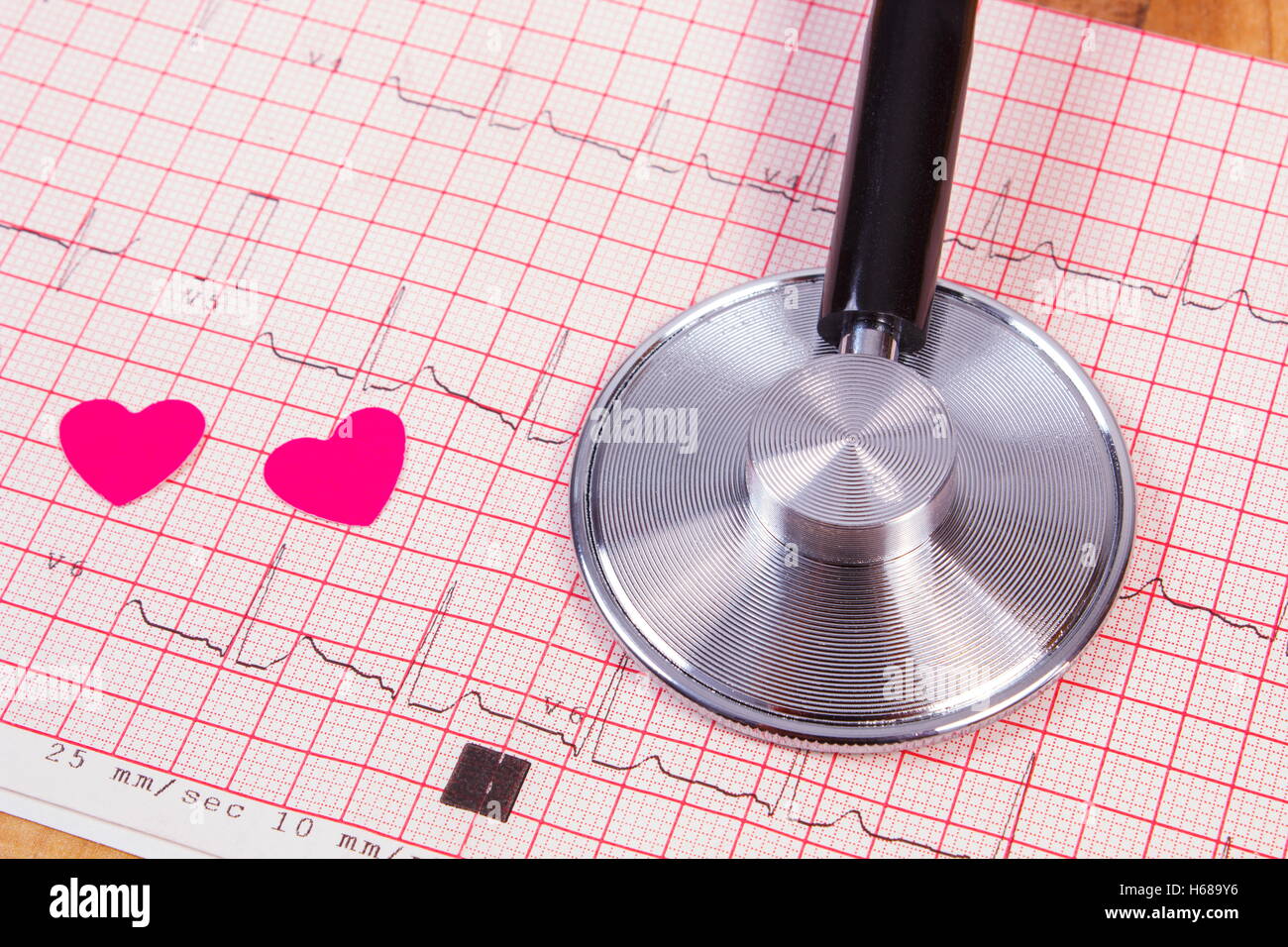 Hearts of paper and medical stethoscope lying on electrocardiogram ...