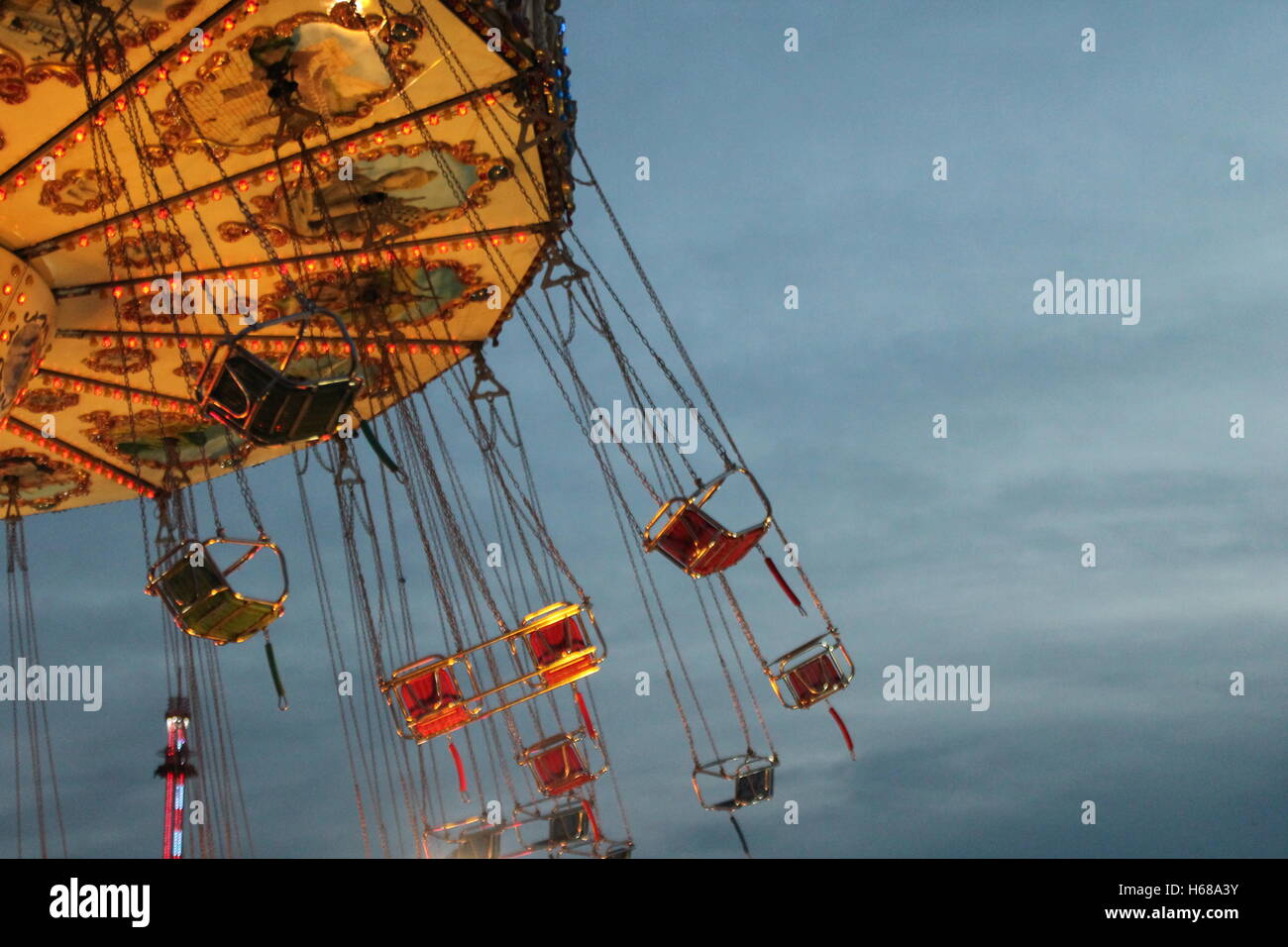 fairground funfair swing ride at dusk toned with retro vintage swings ...