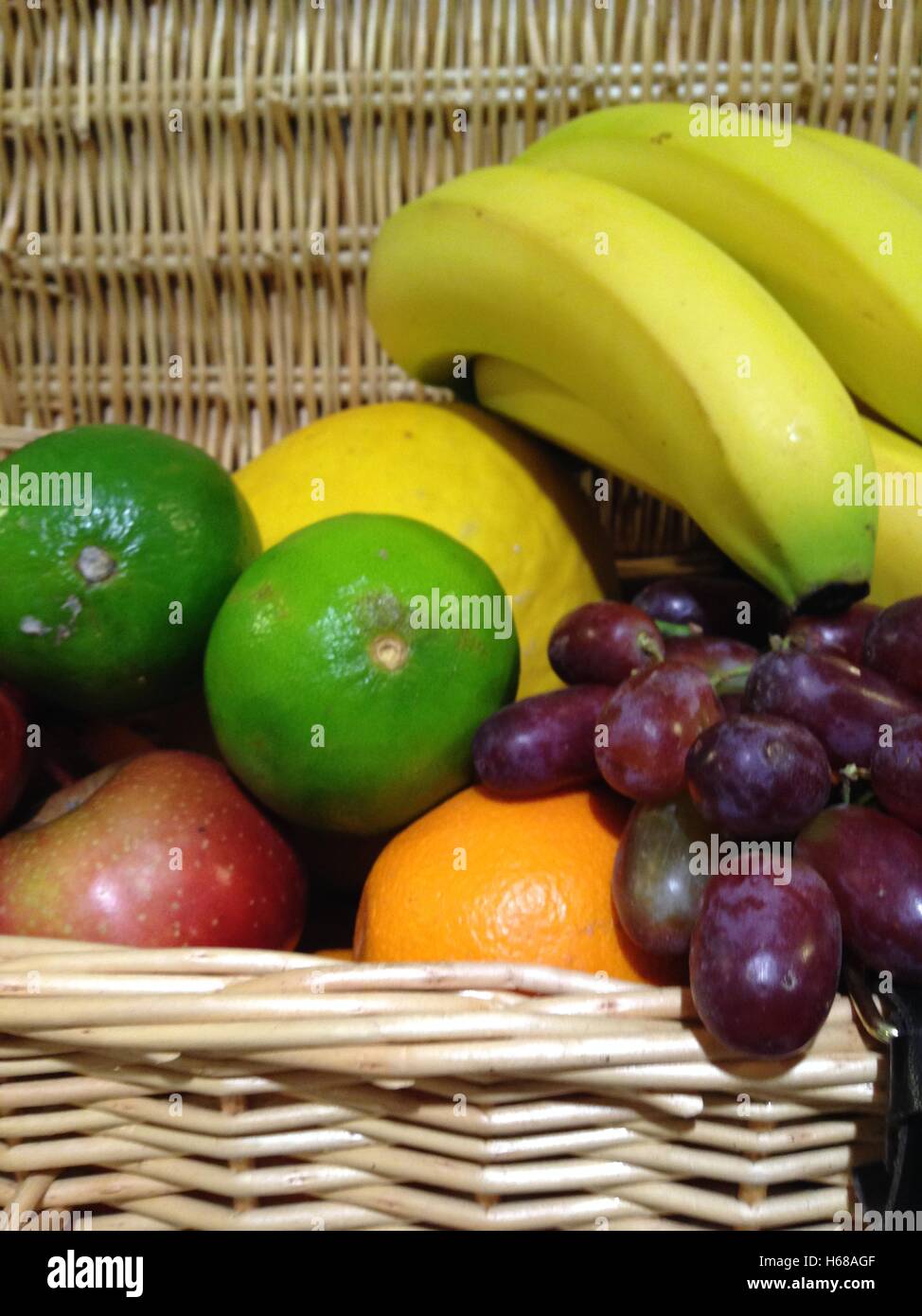 fruit basket wicker with bananas grapes apple Stock Photo - Alamy