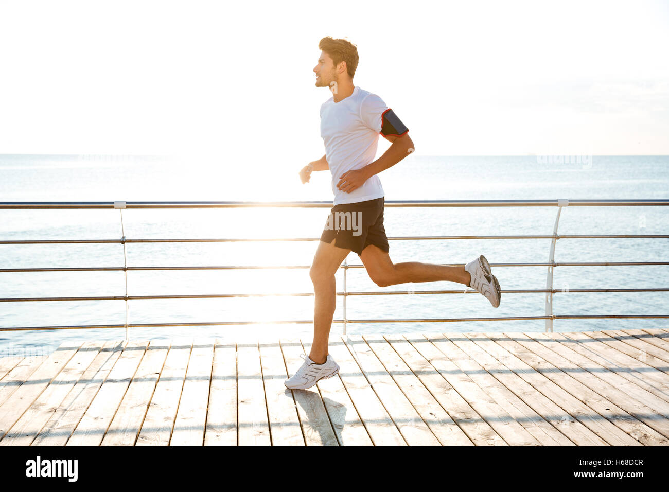 Handsome young man athlete running outdoors in the morning Stock Photo ...