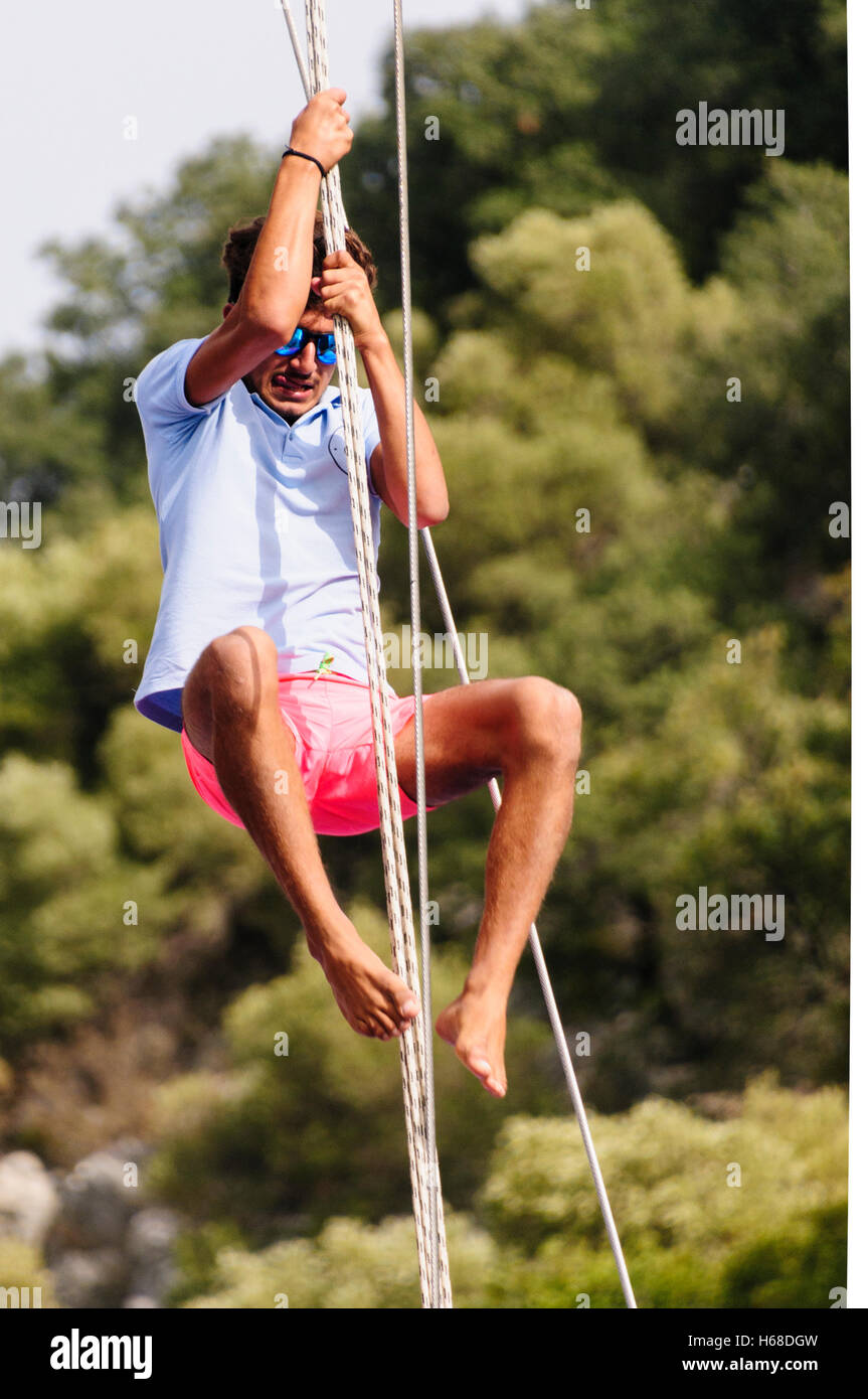 A ships crewmember climbs the rope ropes rigging with bare hands and ...