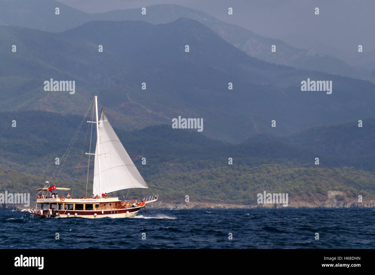 A sailing ship has its foresail unfurled as it crosses a bay in Turkey ...