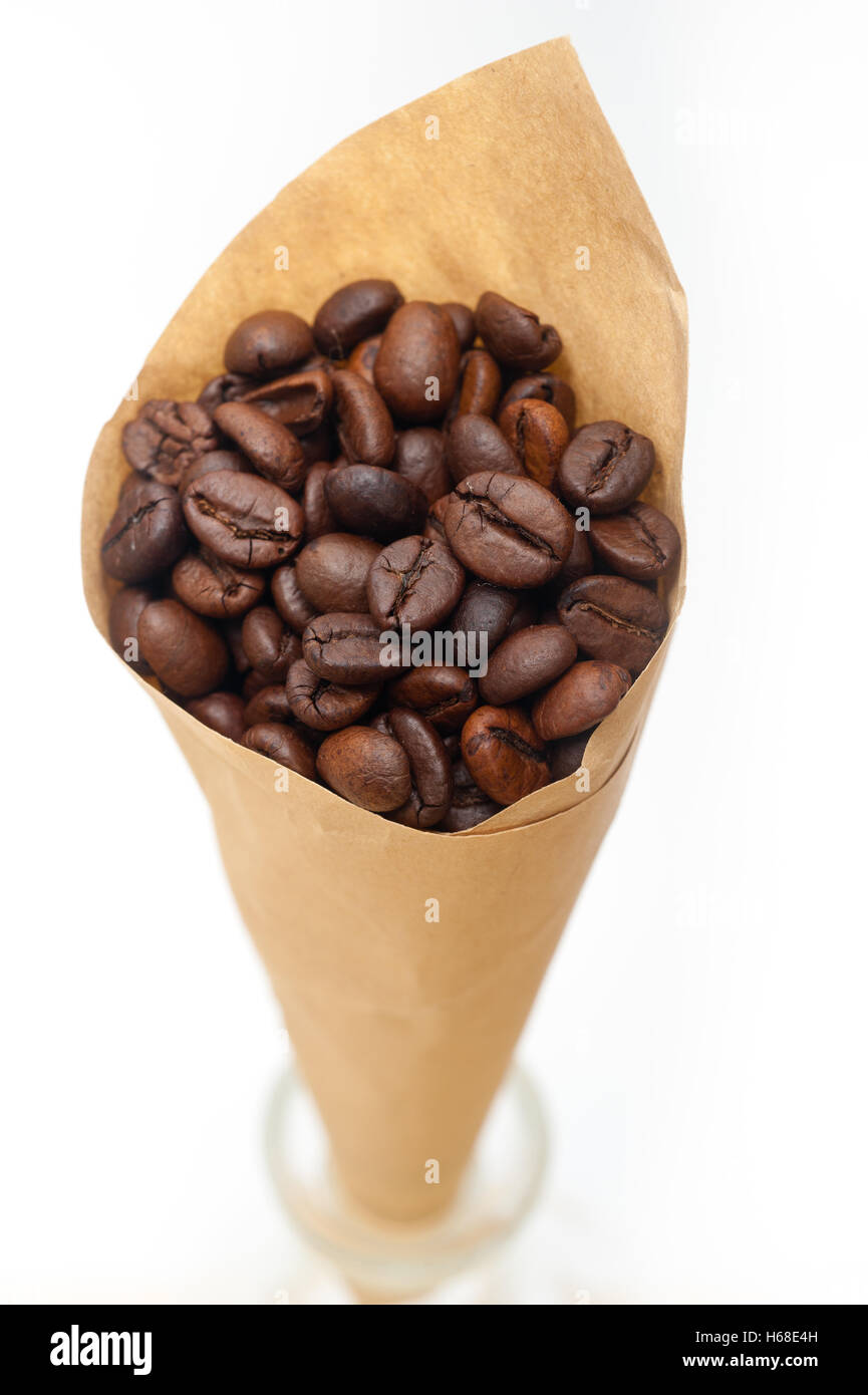 espresso coffee beans on a paper cone cornucopia over white background ...