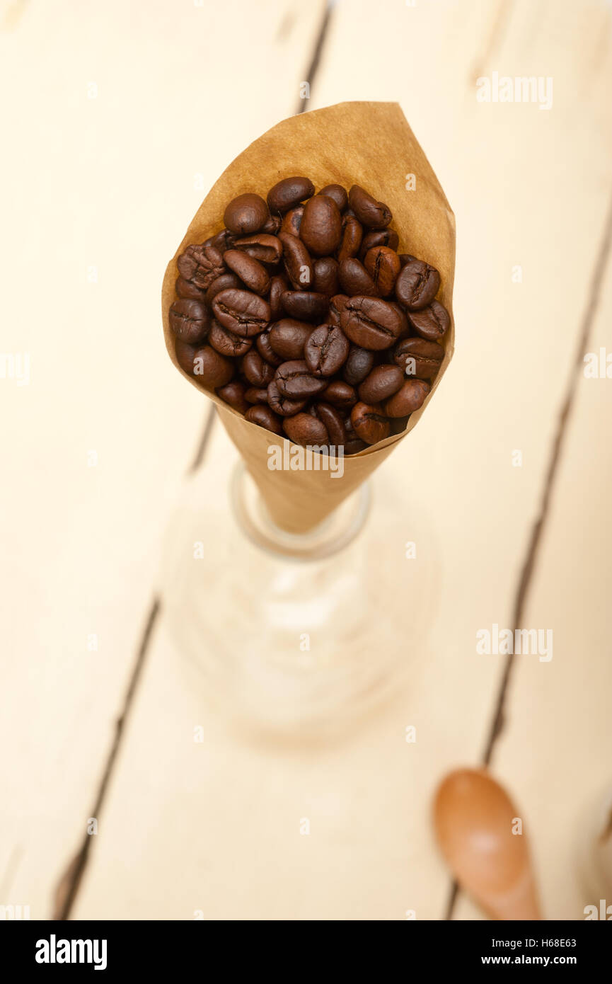 espresso coffee beans on a paper cone cornucopia over white background ...