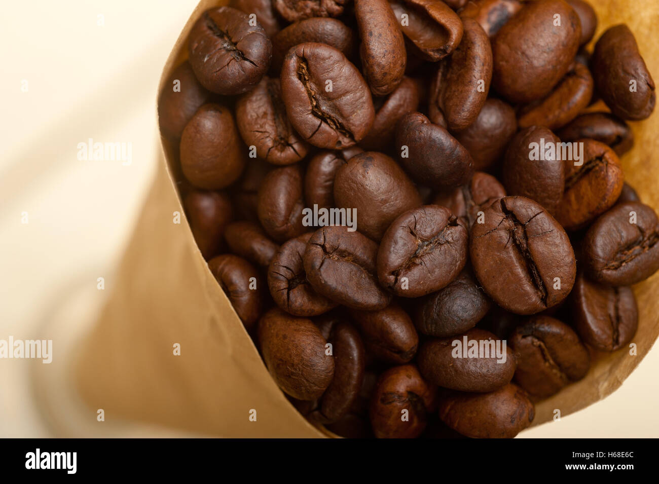 espresso coffee beans on a paper cone cornucopia over white background ...