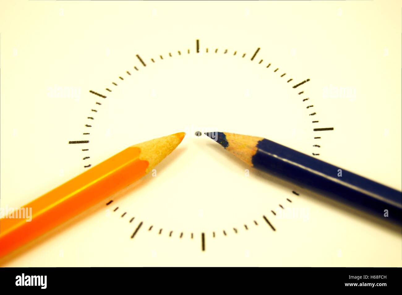 Pencils orange and leu serving as needles on a clock dial Stock Photo ...