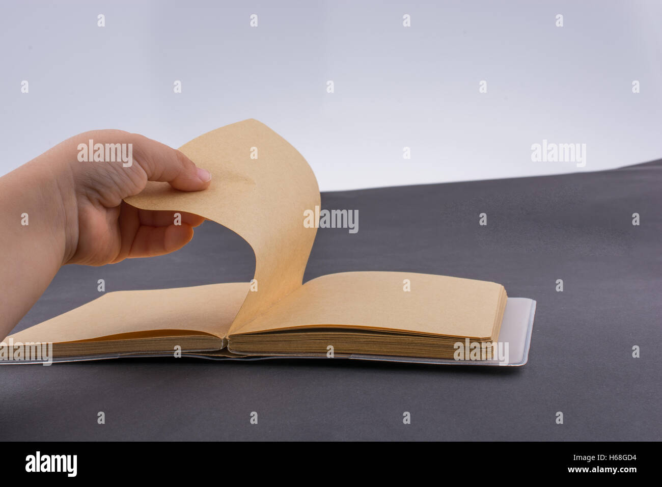 Hand holding brown color notebook on a white background Stock Photo - Alamy