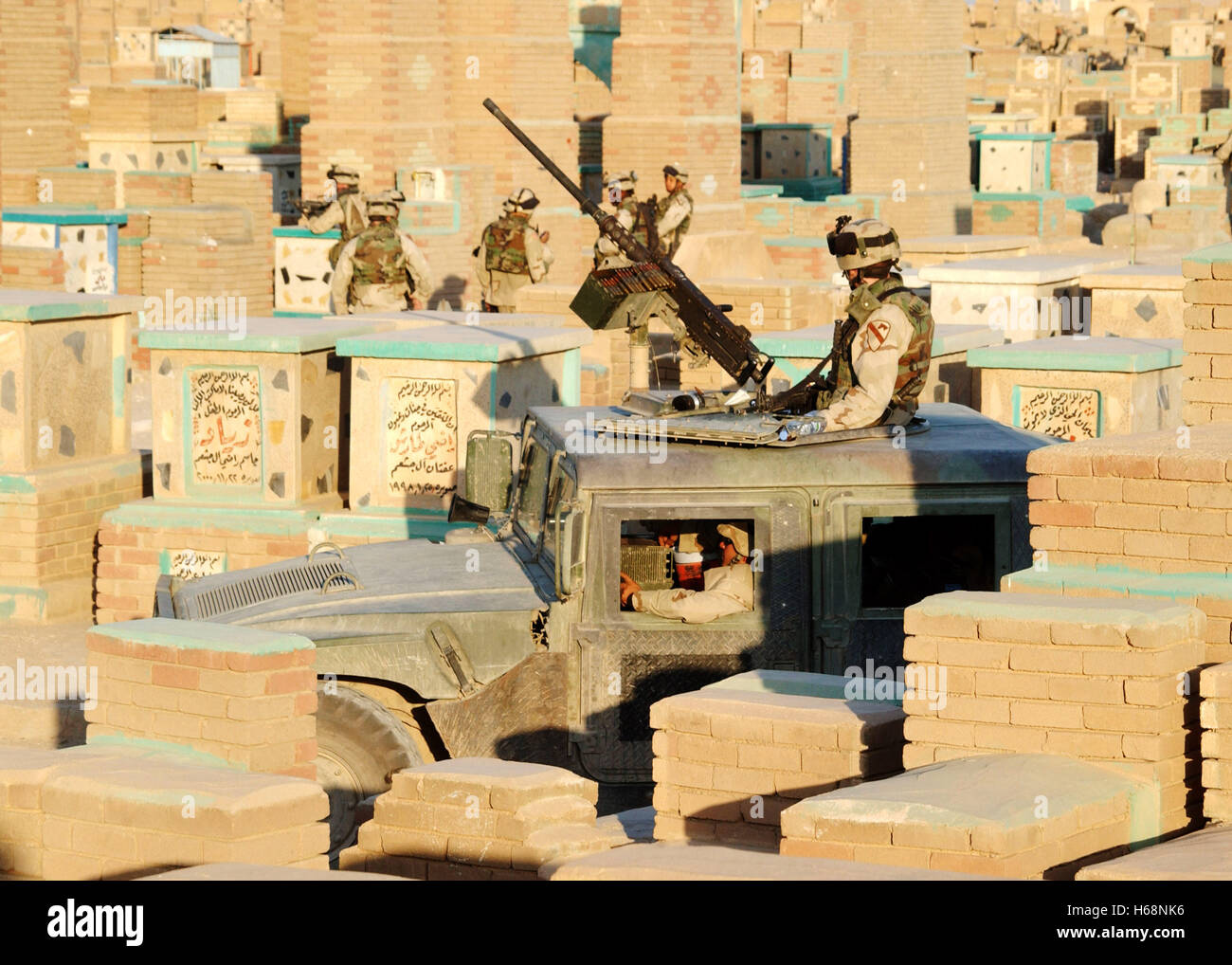 A U. S. soldier mans a .50 caliber machine gun atop a HUMVEE to provide ...