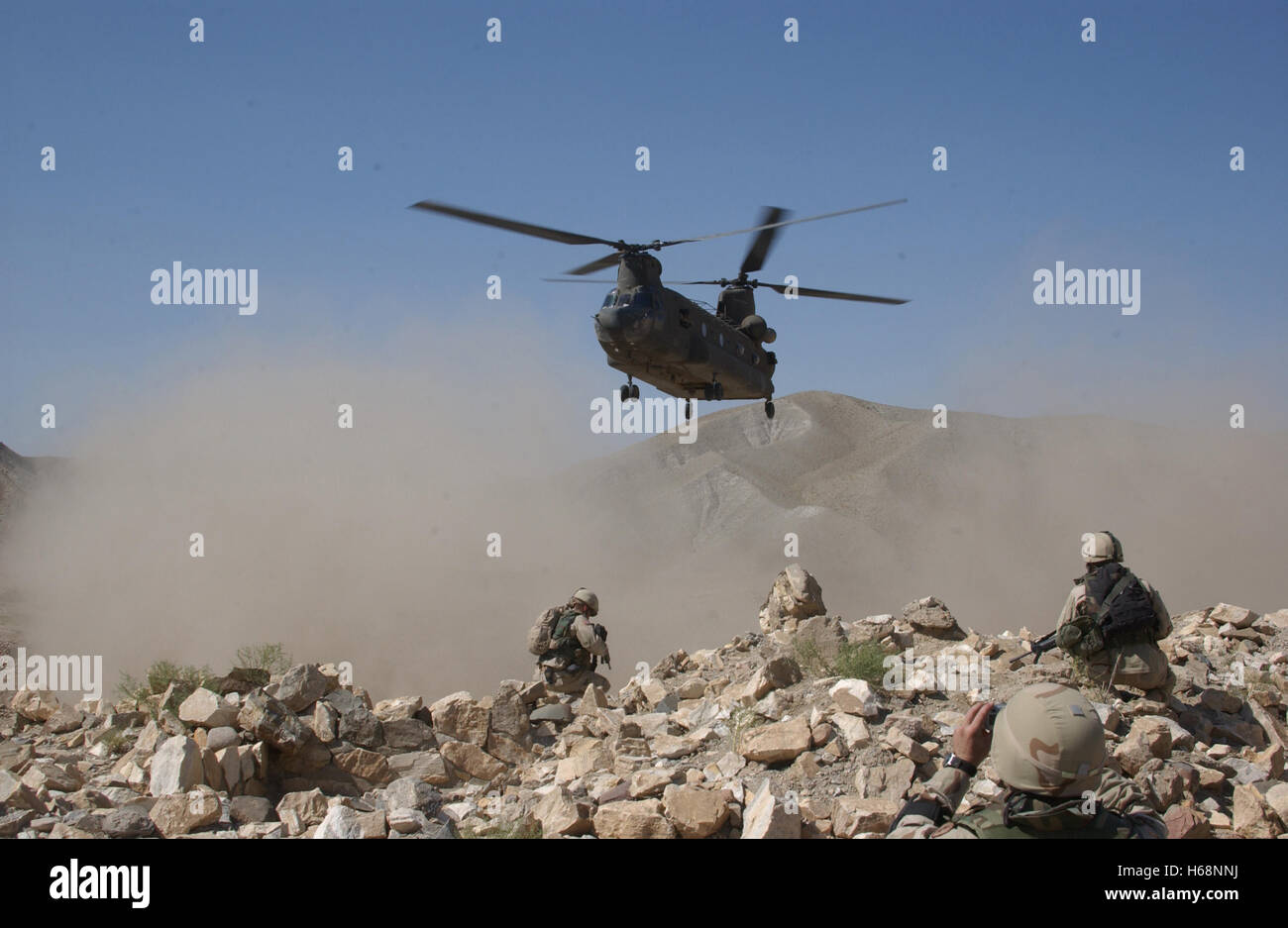 Clouds of dust are kicked up by the rotor wash of a CH-47 Chinook ...