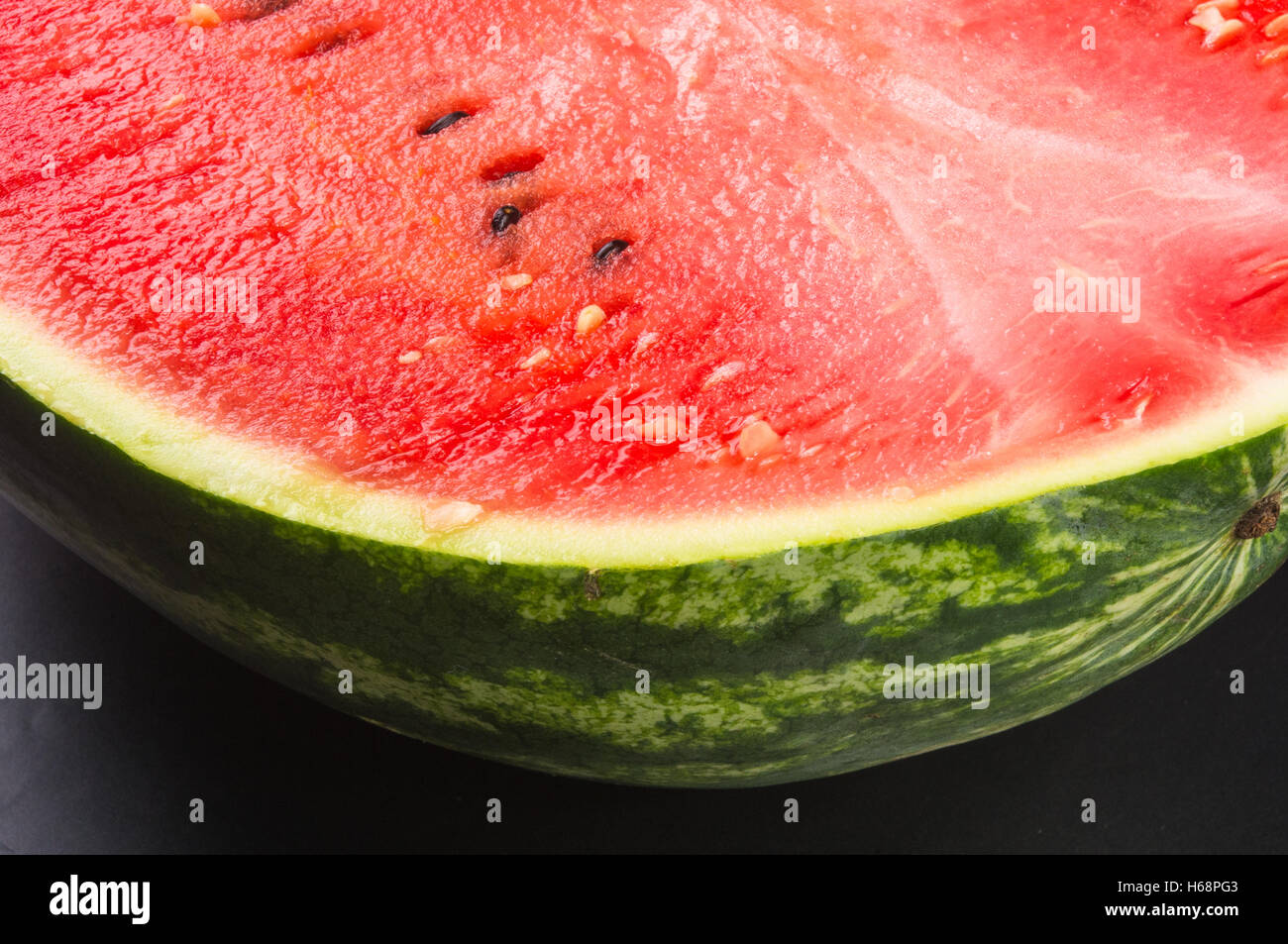 half of ripe watermelon on a black background Stock Photo - Alamy