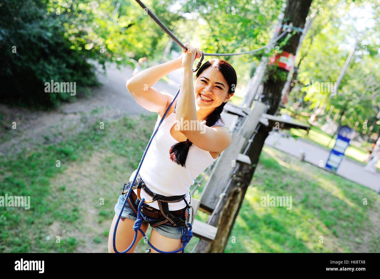 Asian girl passes obstacles ropes course Stock Photo - Alamy