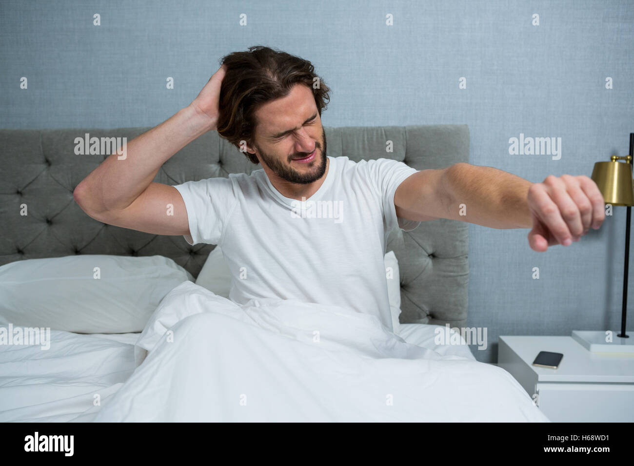 Man waking up in bed and stretching her arms Stock Photo - Alamy