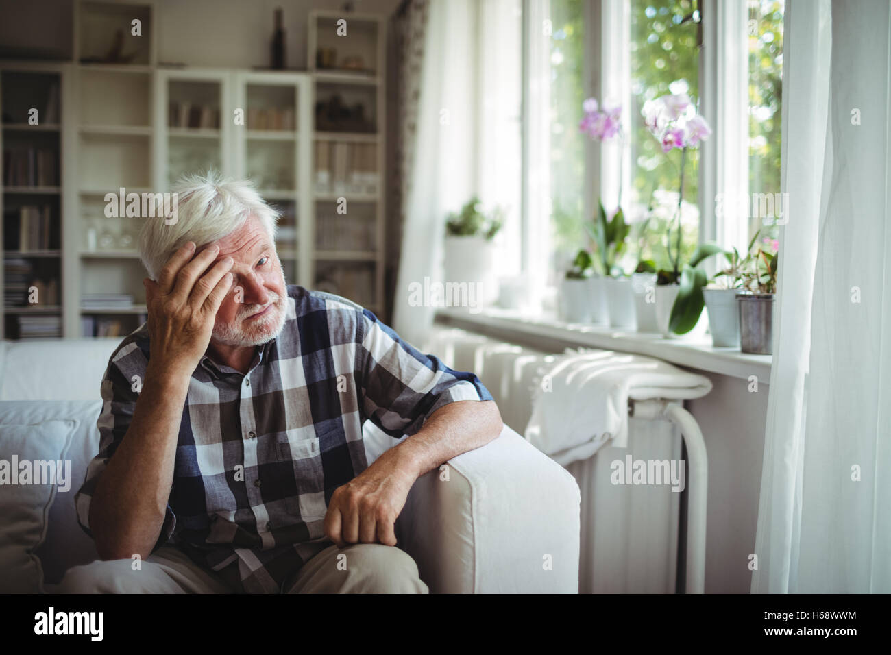 Tensed senior man sitting on sofa Stock Photo - Alamy