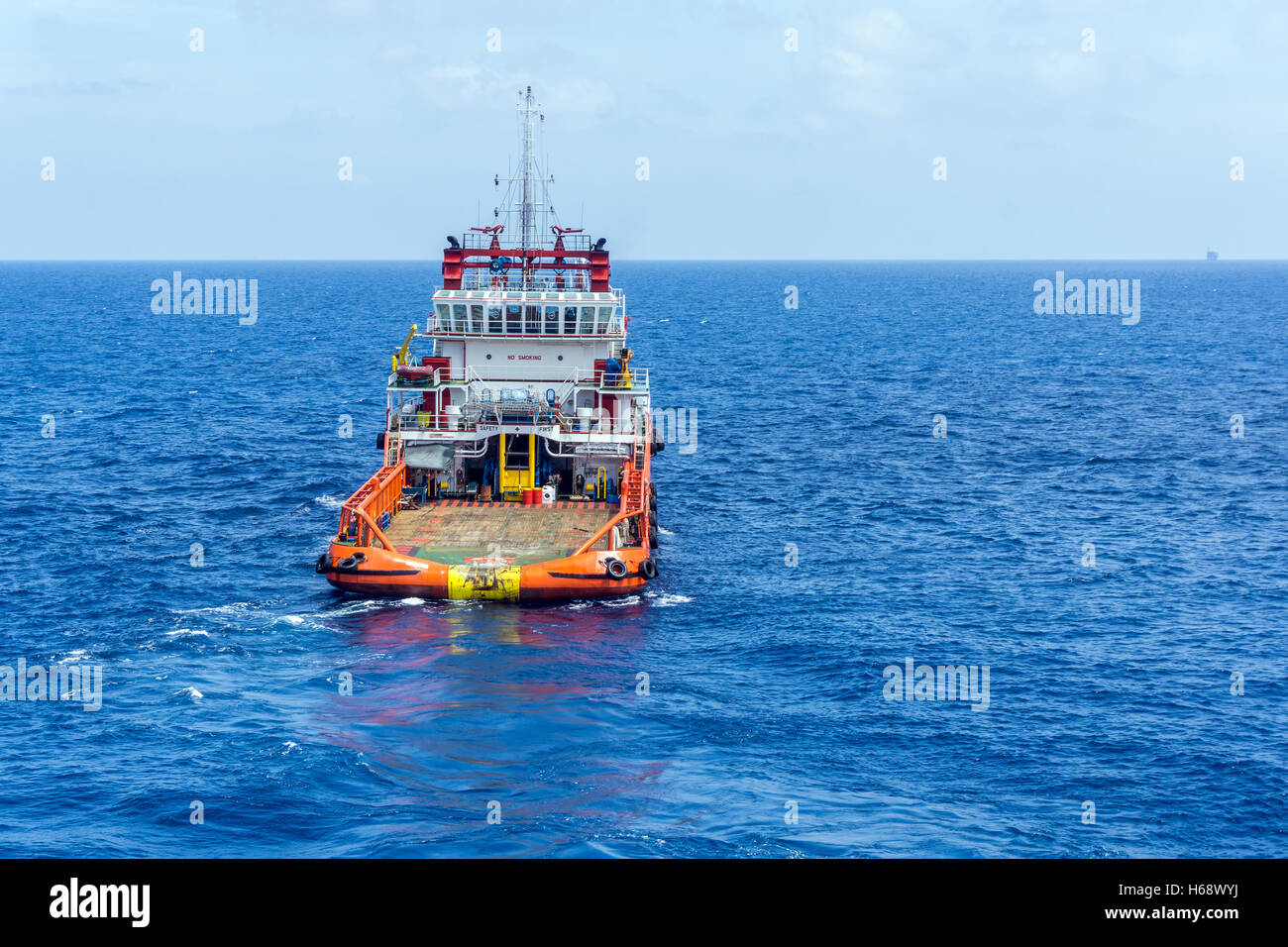 Anchor handling tug deploying anchors of construction barge at oilfield ...