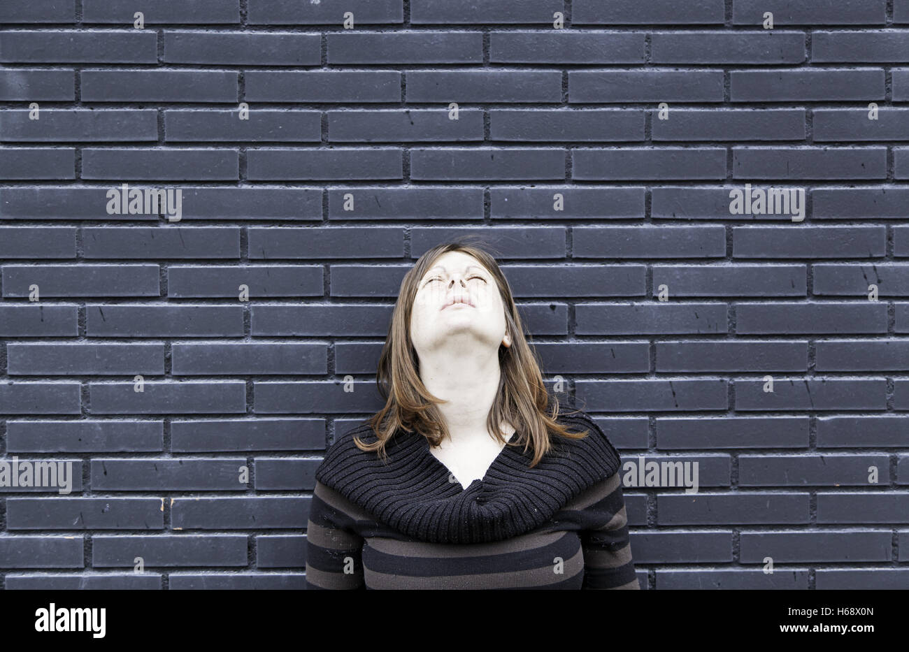 Looking up woman in city street, expression Stock Photo - Alamy