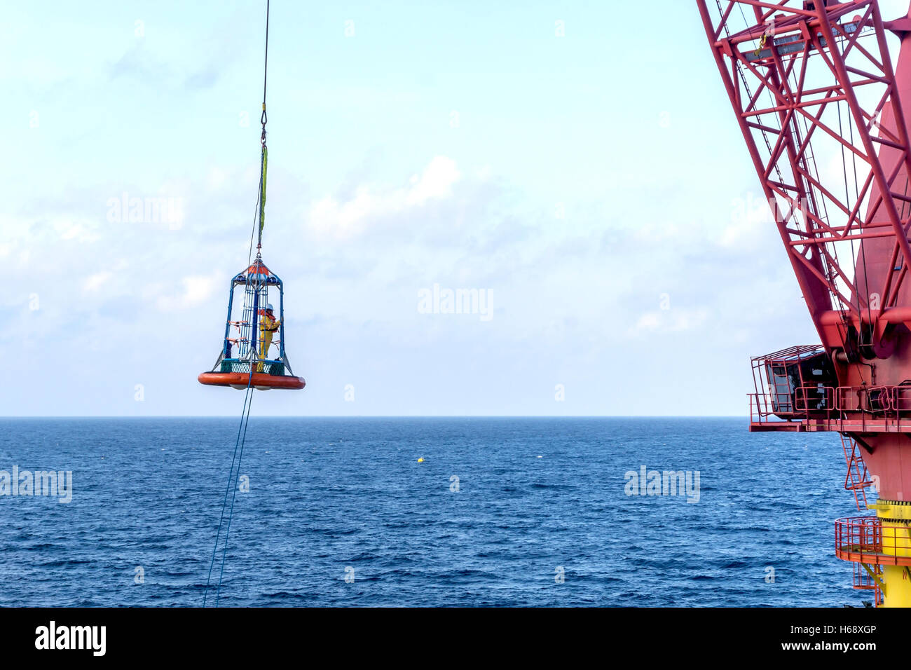 Offshore worker being transferred to boat using personnel basket ...