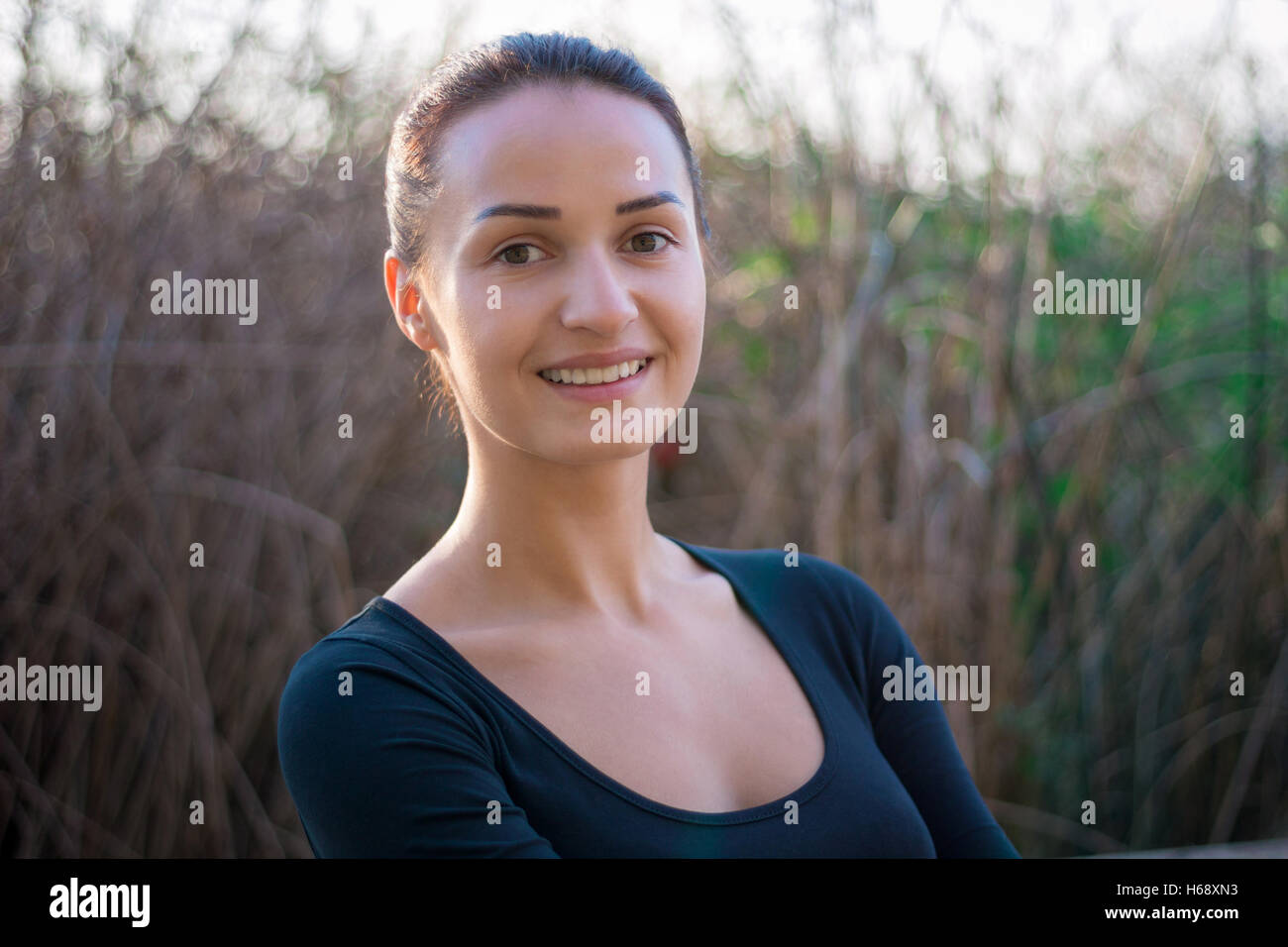 Young pretty woman portrait with water reed background Stock Photo - Alamy