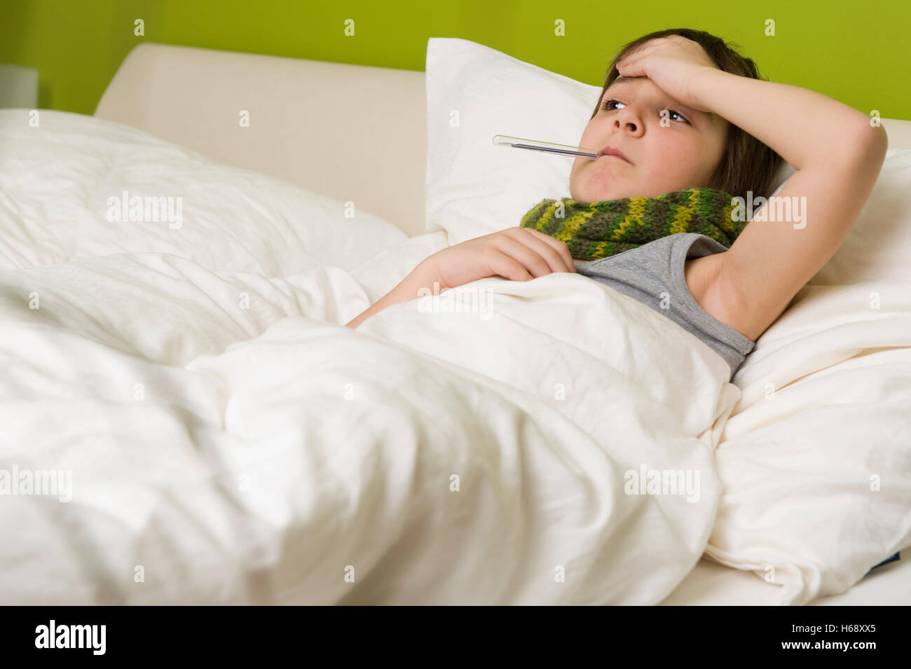 Sick boy with fever in bed, thermometer Stock Photo - Alamy