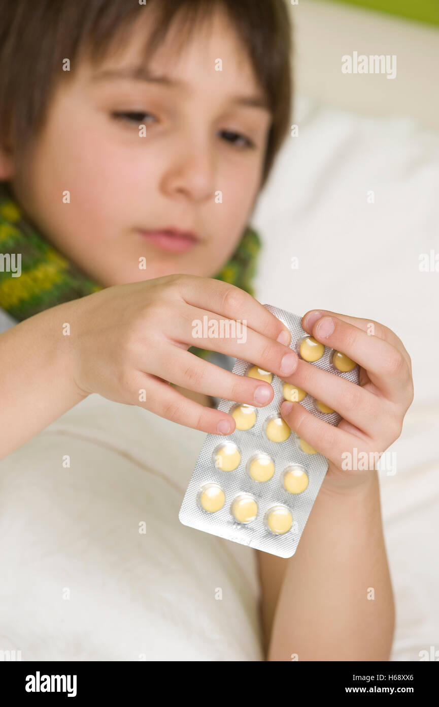 Sick boy taking tablets Stock Photo - Alamy