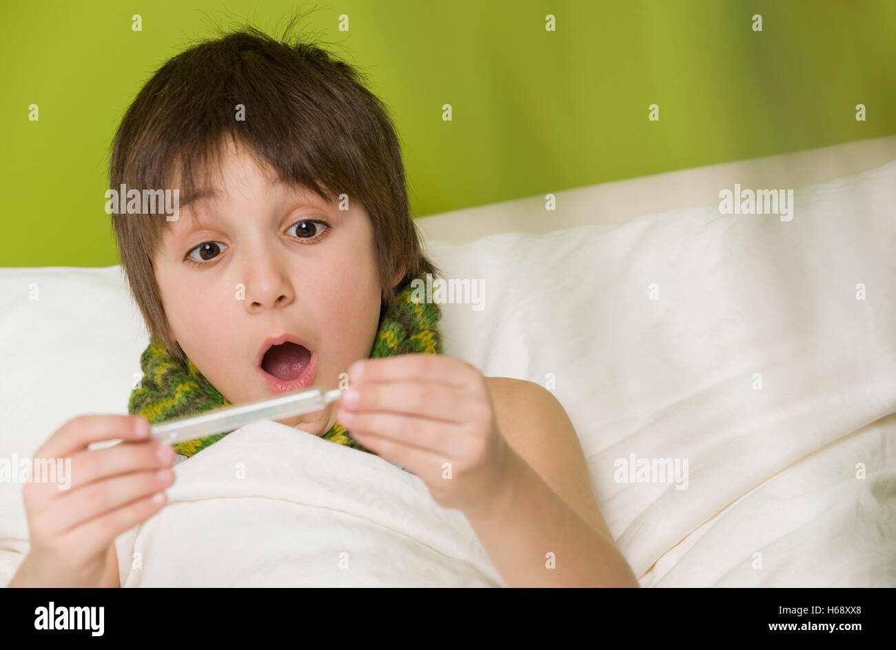Sick boy with fever in bed, thermometer Stock Photo - Alamy