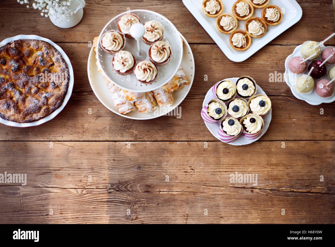 Table with pie, cupcakes, tarts and cakepops. Copy space Stock Photo ...