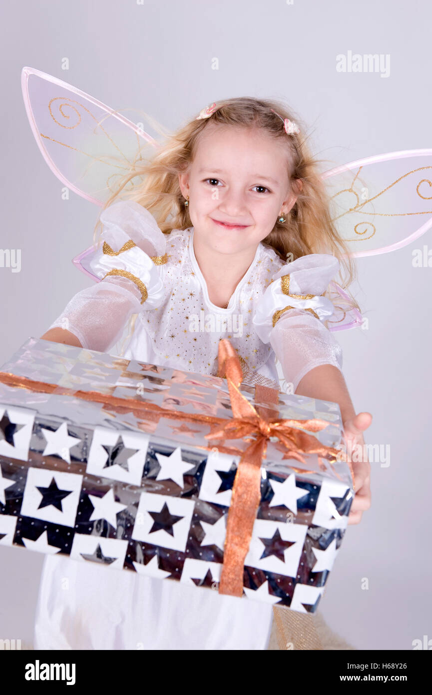 Girl as angel with Christmas present Stock Photo - Alamy