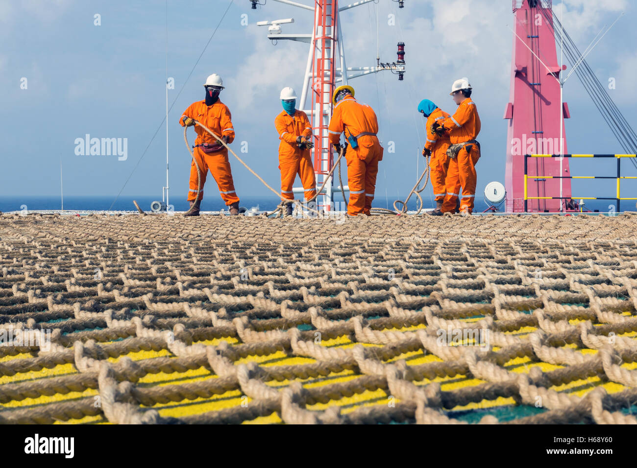 Offshore workers working on the helideck of a construction barge Stock ...