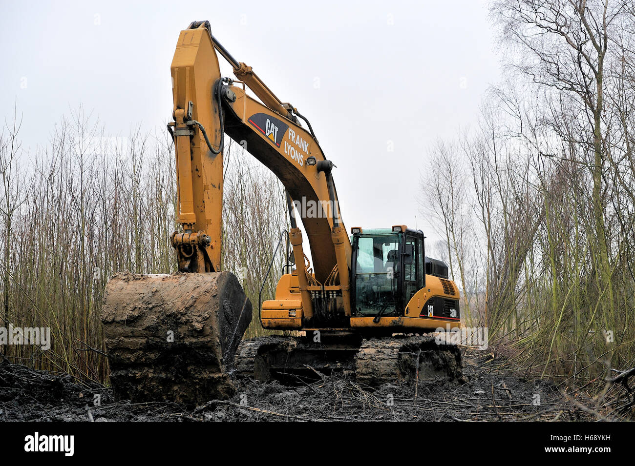 A large digger in the process of attempting to pull another smaller ...