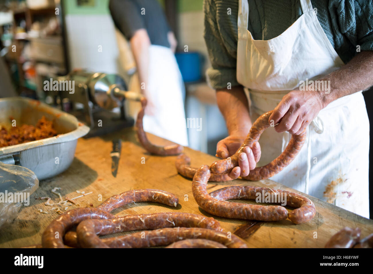 Men making sausages the traditional way using sausage filler Stock ...