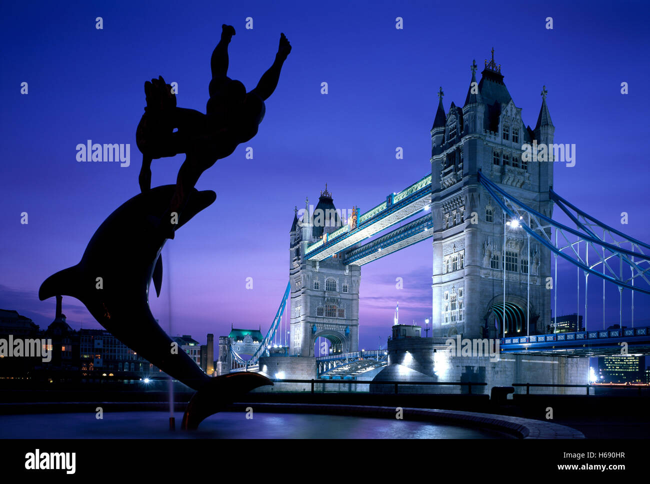 Tower Bridge at dusk with Dolphin and Mermaid statue, London, England ...