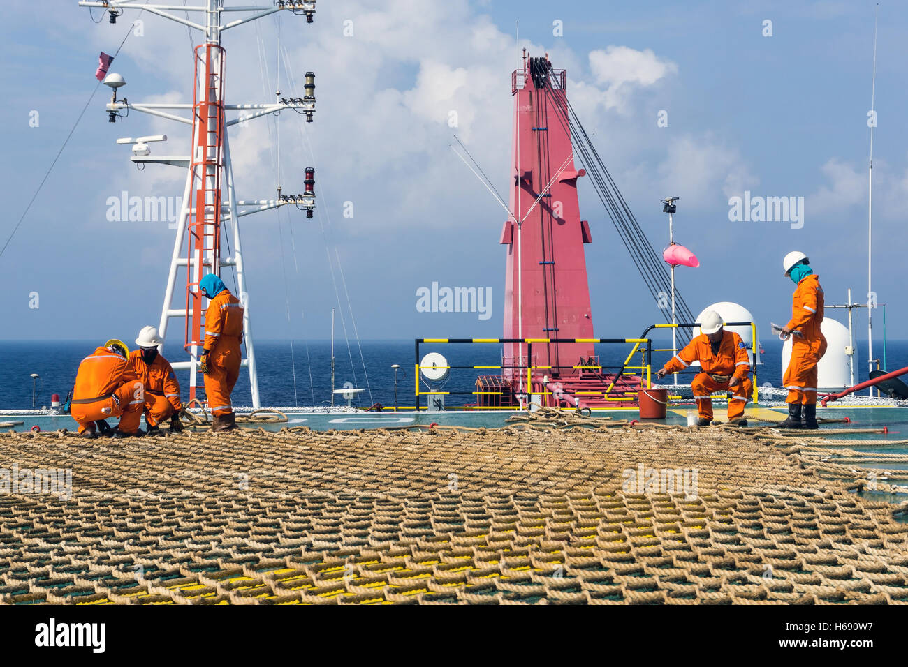 Offshore workers working on the helideck of a construction barge Stock ...