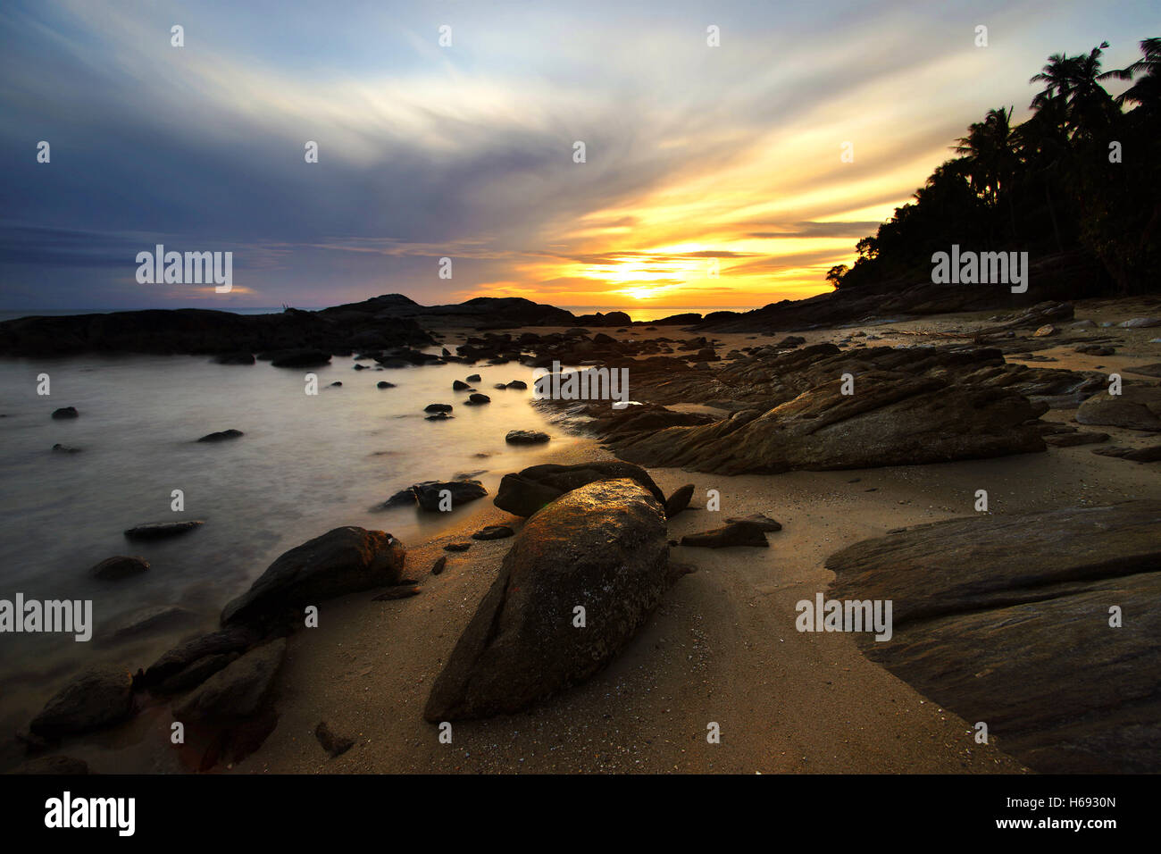 rocks in calm sea with beautiful sunrise background Stock Photo - Alamy