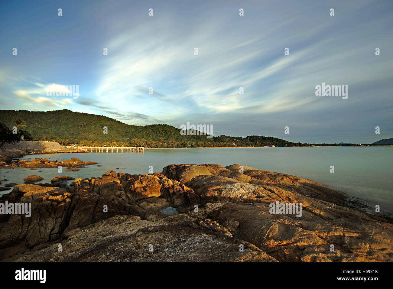 rocks in calm sea with beautiful sunrise background Stock Photo - Alamy