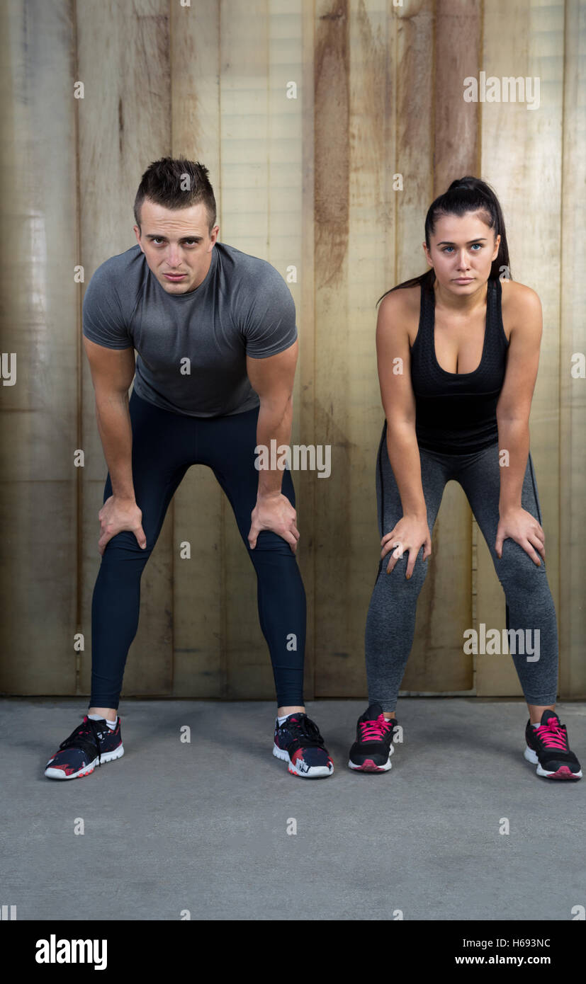 Fit couple after exercise at crossfit gym against rustic background ...