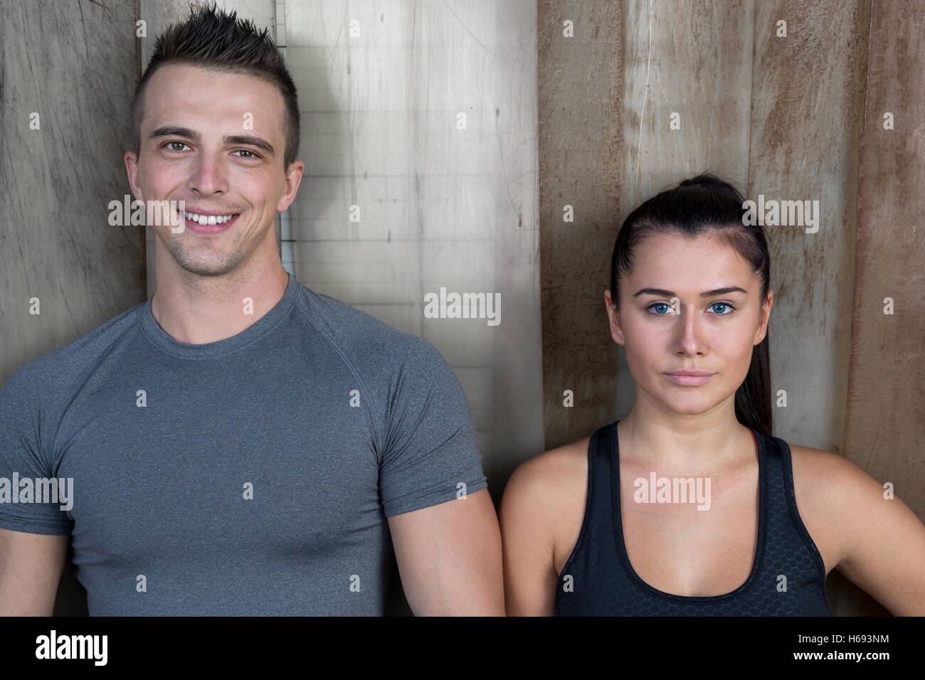 Fit couple after exercise at crossfit gym against rustic background ...