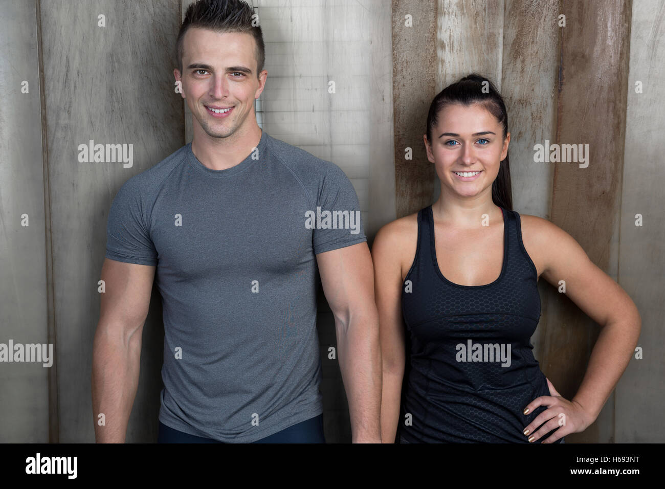 Fit couple after exercise at crossfit gym against rustic background ...