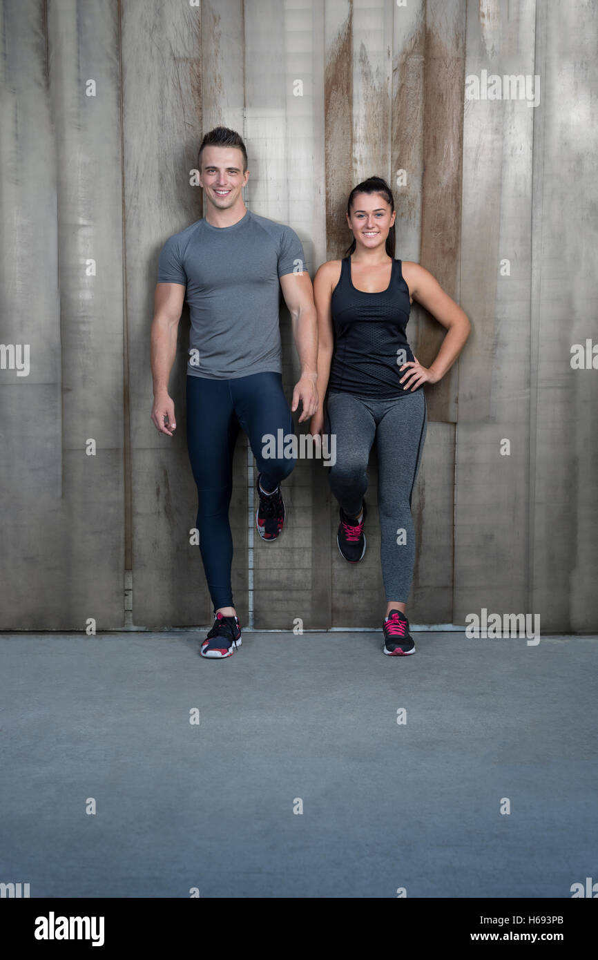 Fit couple after exercise at crossfit gym against rustic background ...