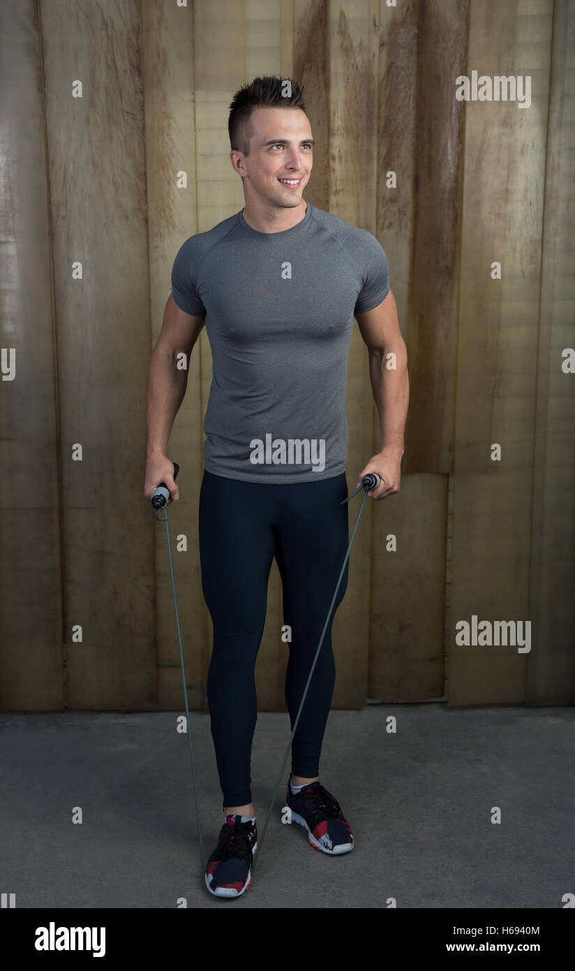 Muscular man skipping rope. Portrait of muscular young man exercising ...