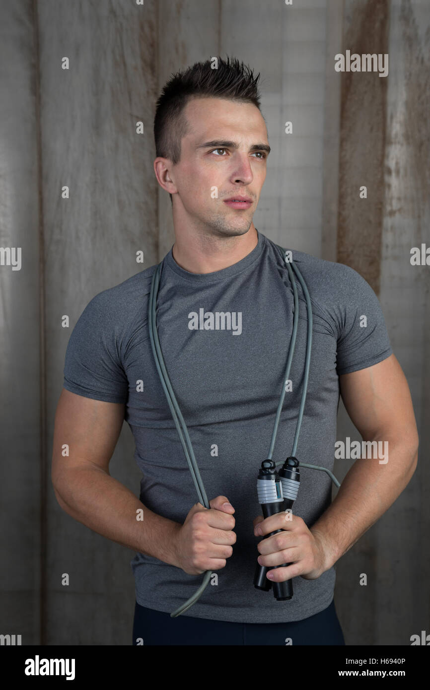 Handsome muscular man with jumping rope on rustic background Stock ...