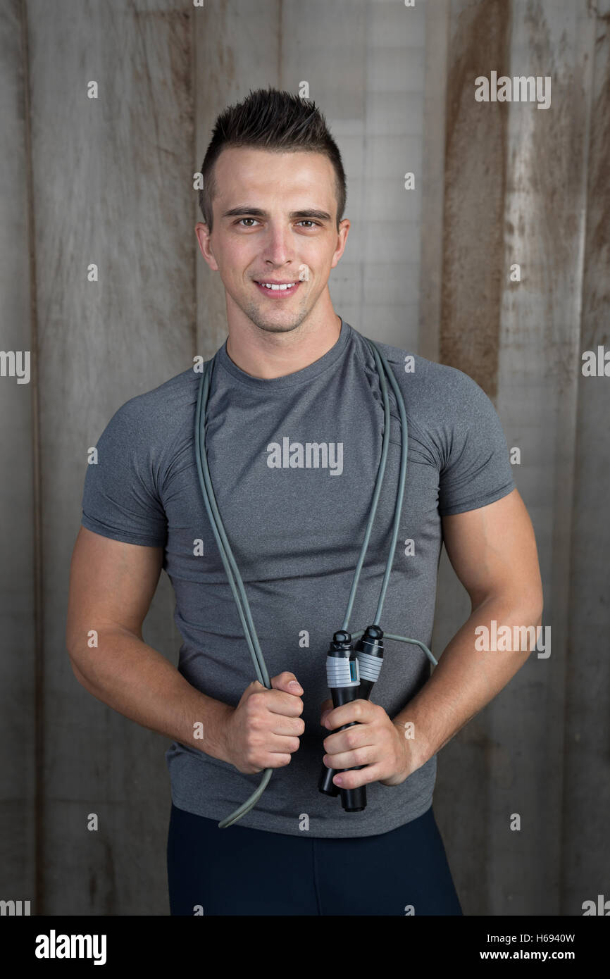Muscular man skipping rope. Portrait of muscular young man exercising ...