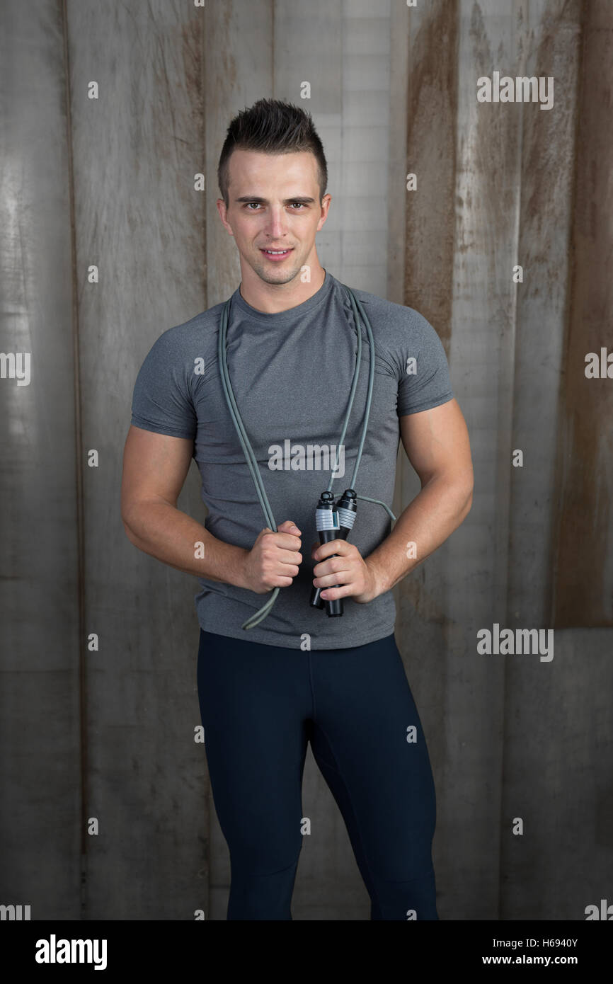 Muscular man skipping rope. Portrait of muscular young man exercising ...