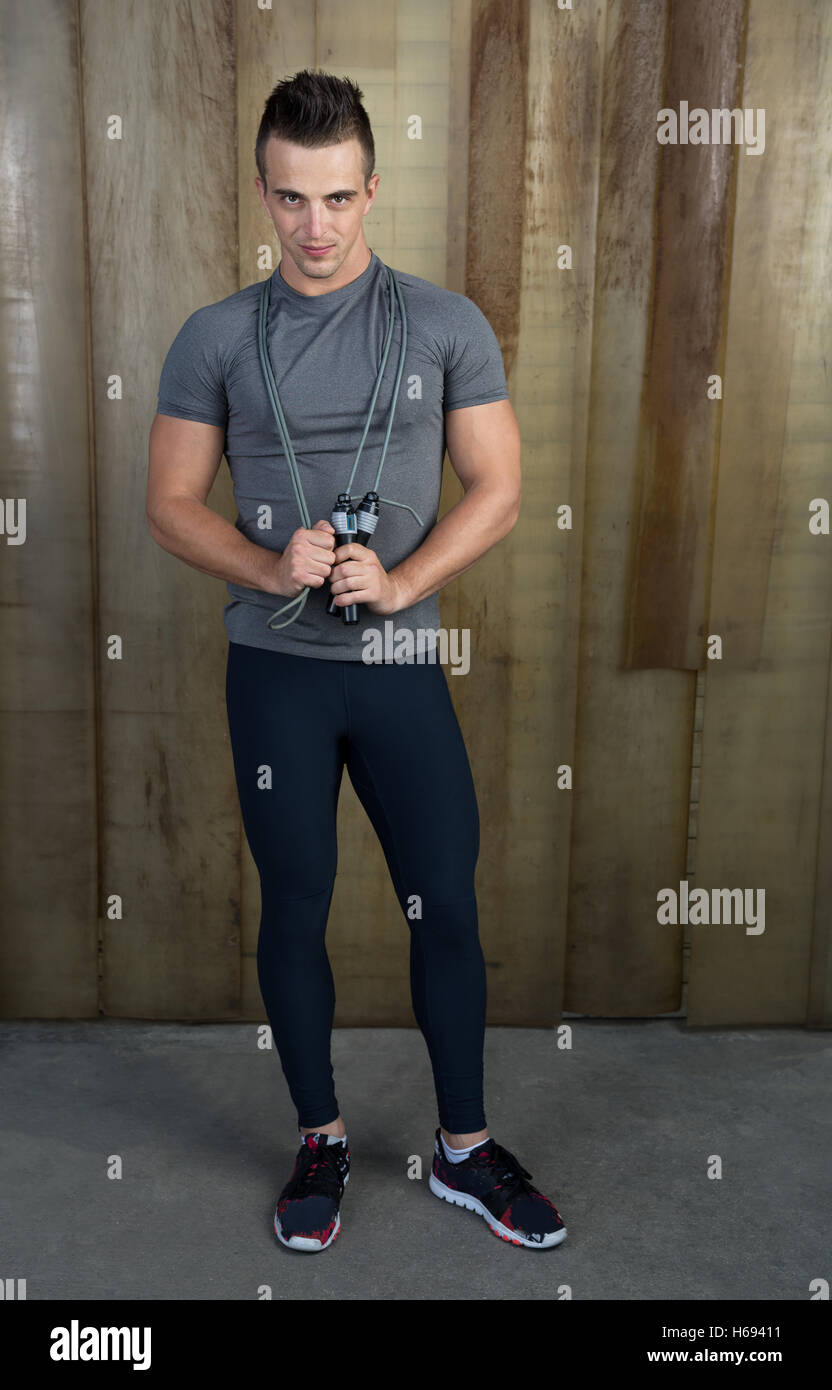 Muscular man skipping rope. Portrait of muscular young man exercising ...