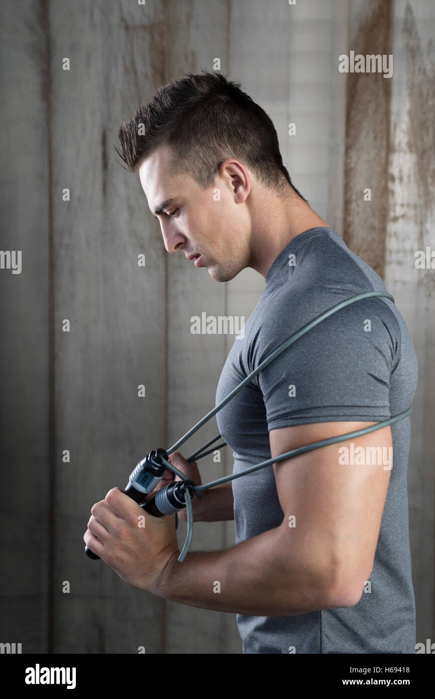 Handsome muscular man with jumping rope on rustic background Stock ...