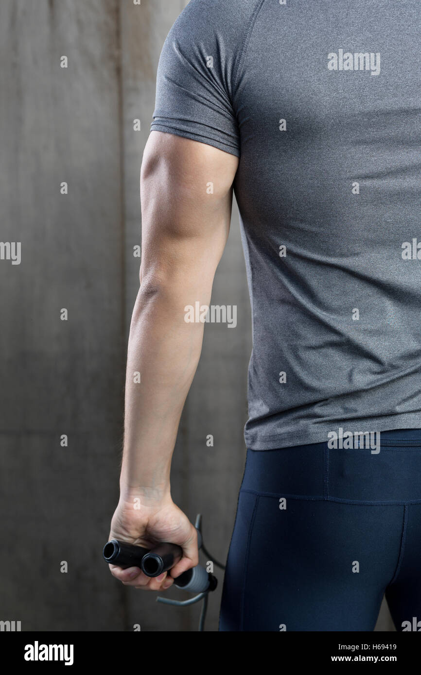 Muscular man skipping rope. Portrait of muscular young man exercising ...