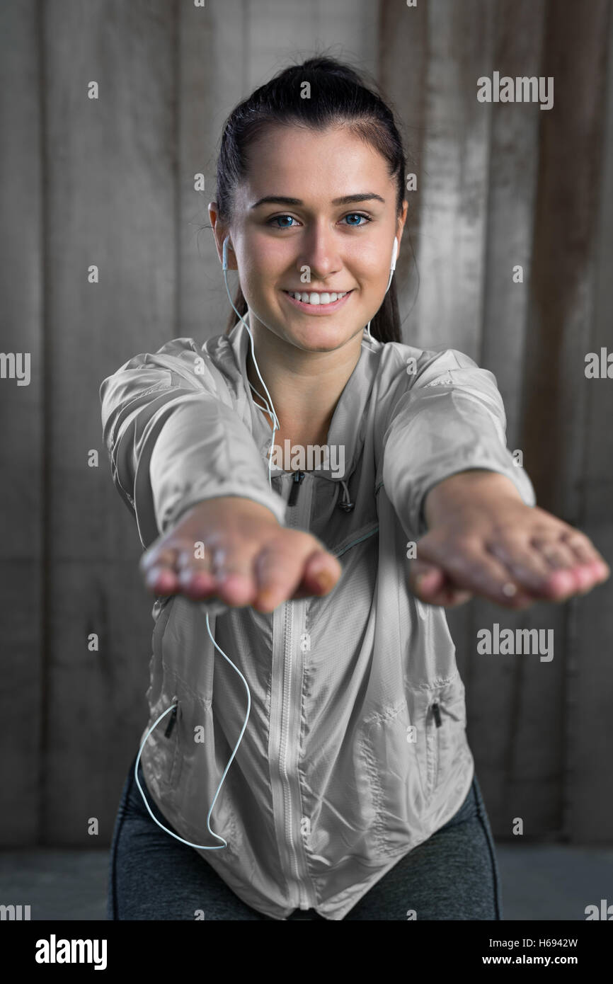 Deep squat. Front view of young beautiful woman in sportswear doing ...