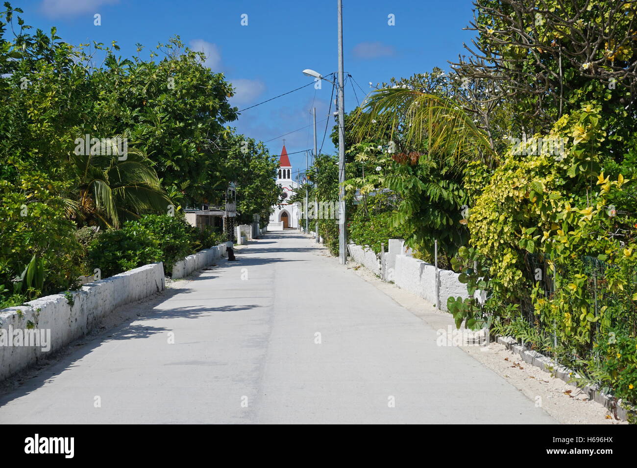 Peaceful street with tropical vegetation and a church at the end in the ...