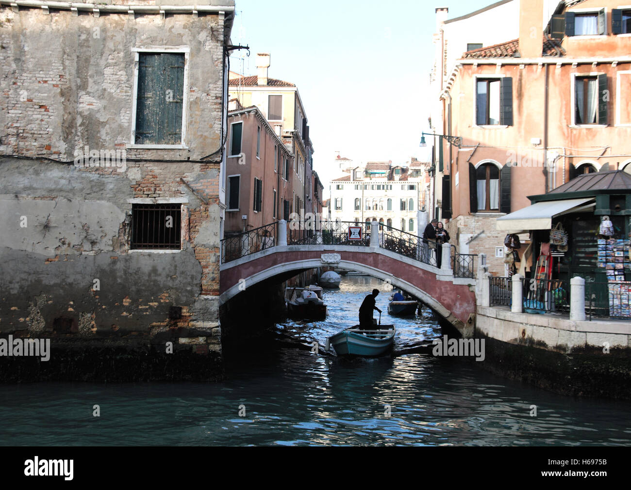 A common sight in Venice--a man in silhouette manoevres his boat ...