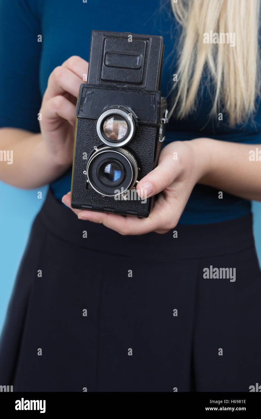 Pretty young girl with retro vintage camera standing and smiling ...