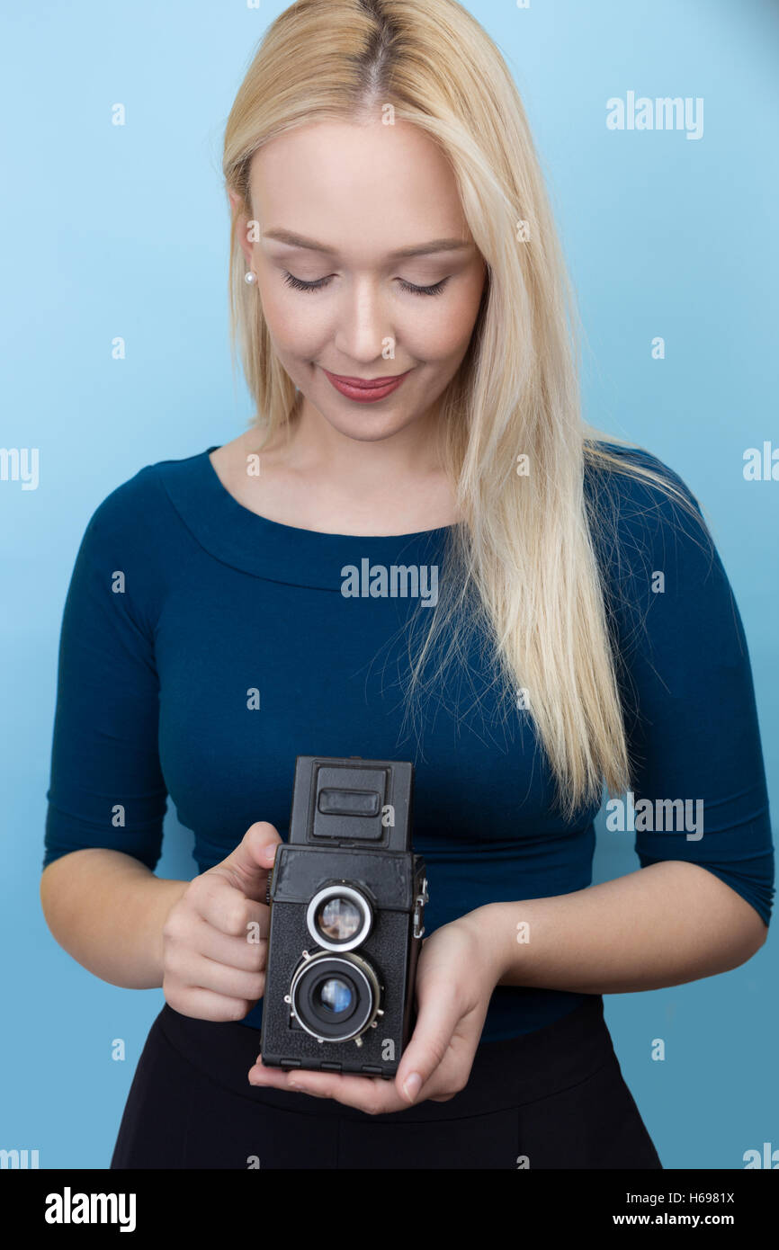 Pretty young girl with retro vintage camera standing and smiling ...