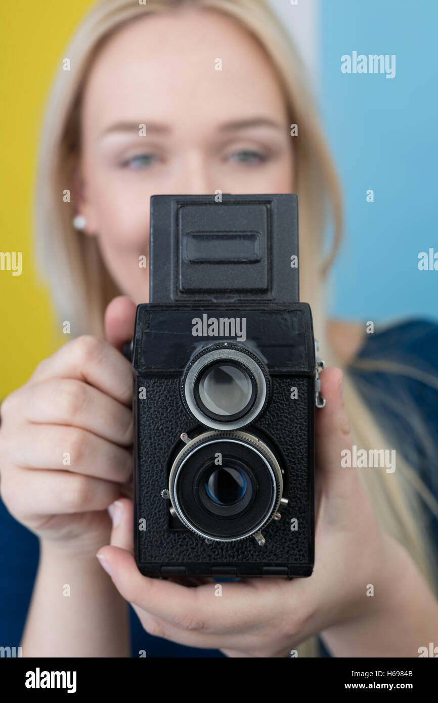 Pretty young girl with retro vintage camera standing and smiling ...